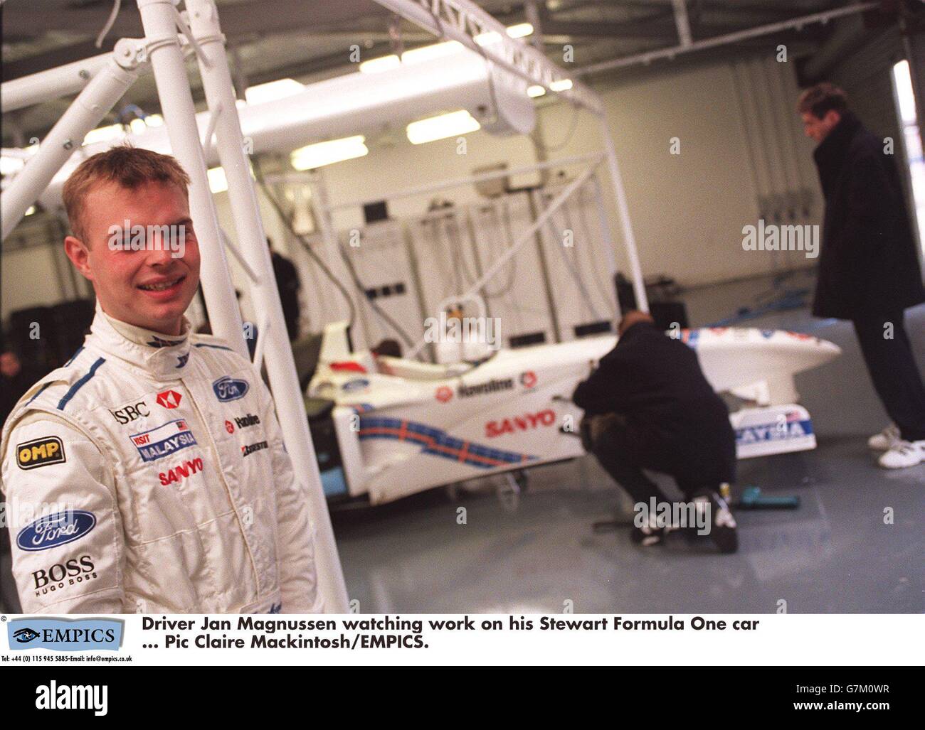 Driver Jan Magnussen watching work on his Stewart Formula One car Stock ...