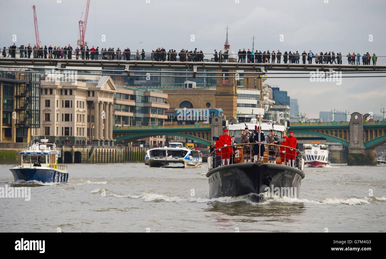 Crowds watch from the Millennium Bridge as the Havengore barge passes ...