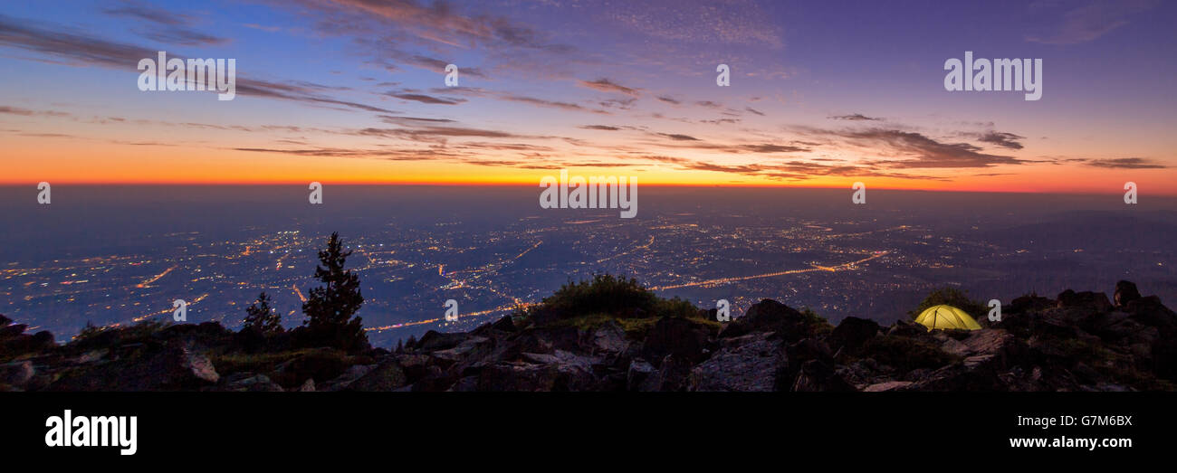 camping in the mountains and beautiful sunrise over the city in Europe ...