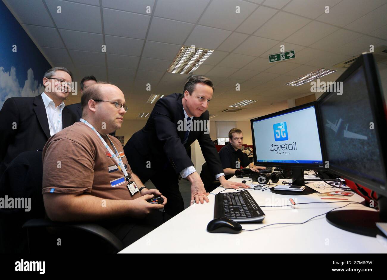 Prime Minister David Cameron (right) is shown a flight simulator by ...