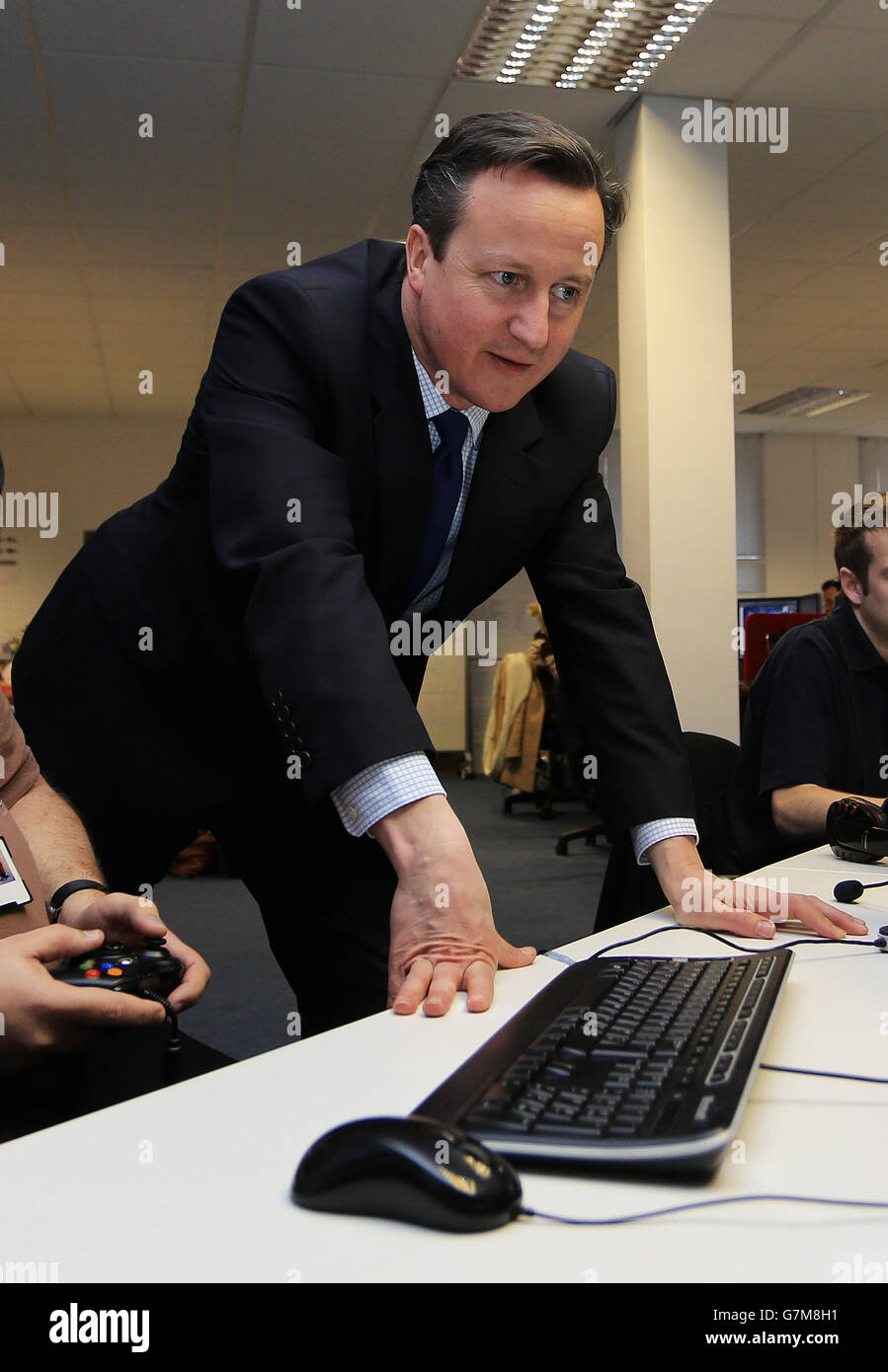 Prime Minister David Cameron (right) is shown a flight simulator by ...