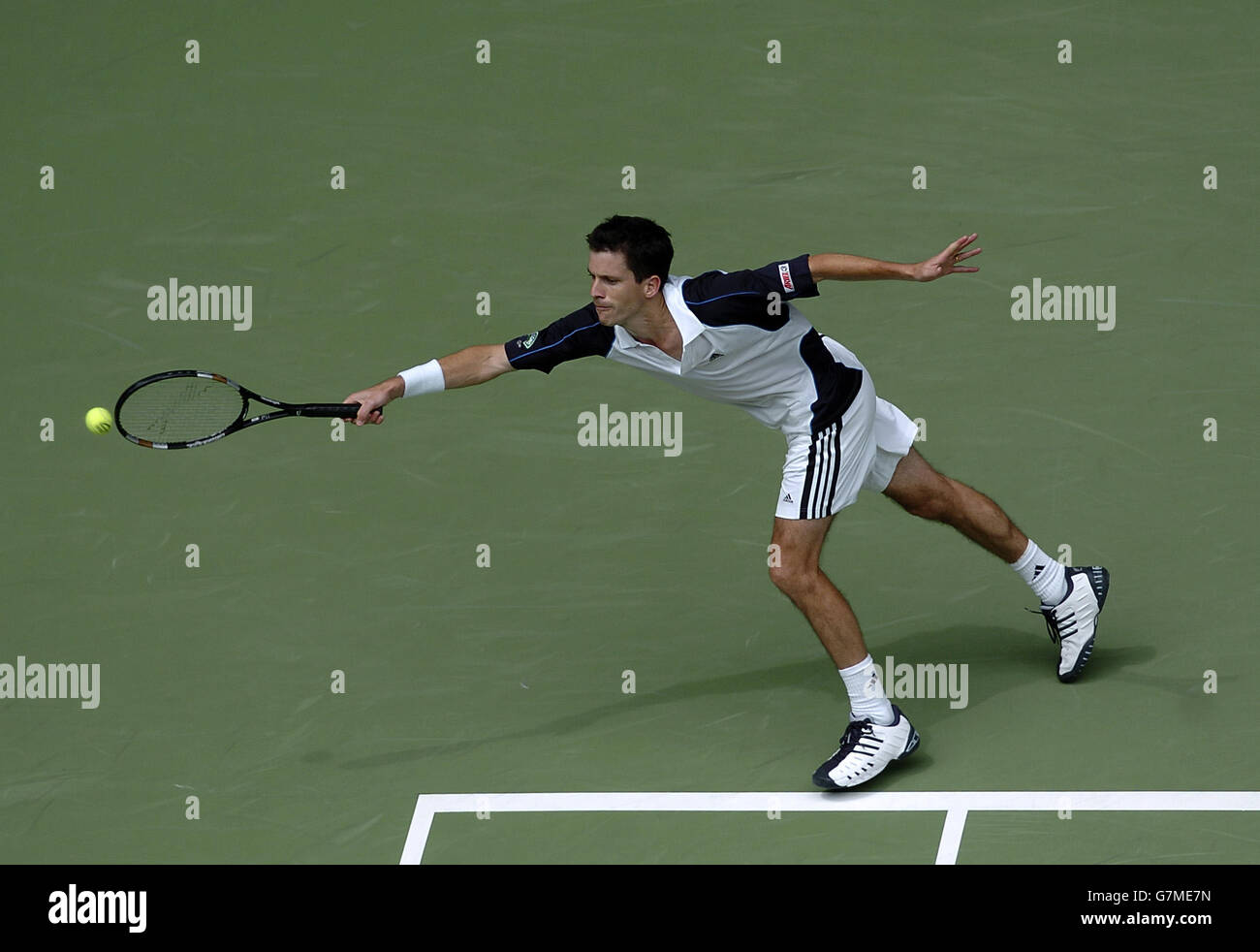 Tim Henman lunges for the ball during his match against Nikolay ...