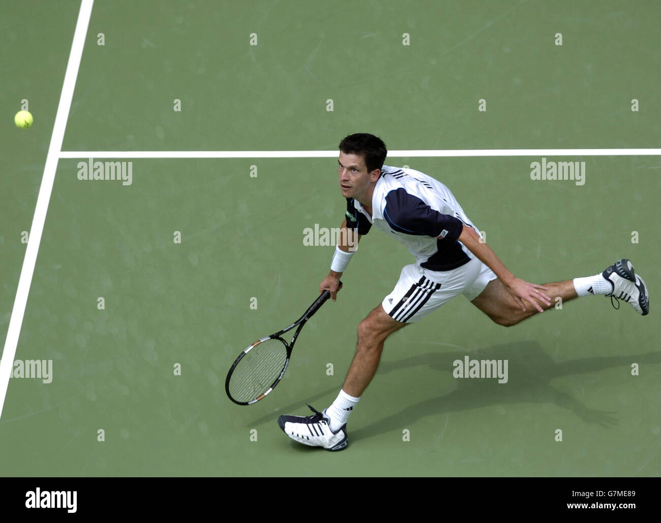 Tim Henman lunges for the ball during his match against Nikolay ...