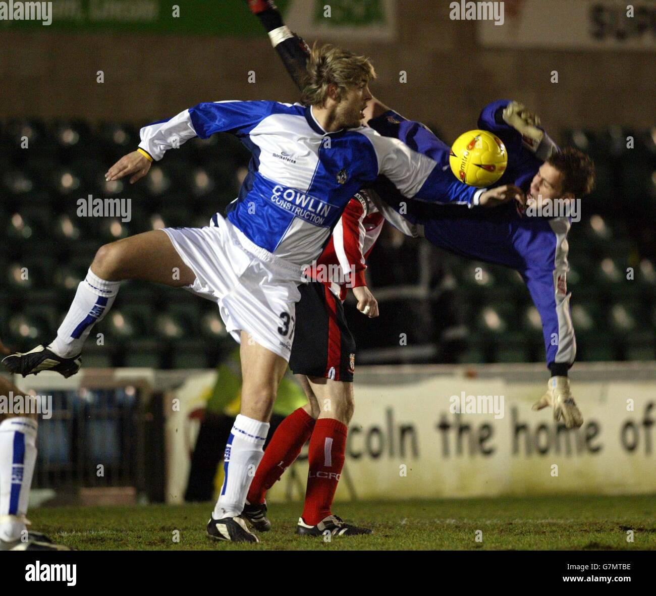 Lincoln City goalkeeper Alan Marriott takes a tumble after a clash with ...
