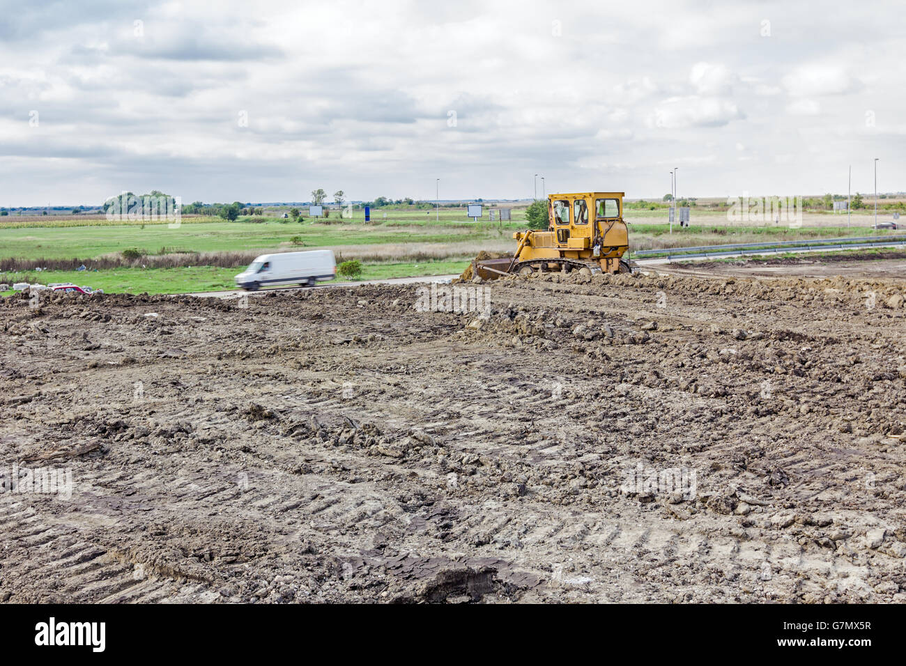 Earthmover with caterpillar is moving earth outdoors Stock Photo - Alamy