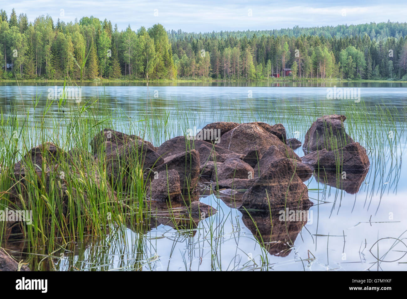 Lake with Rocks and Forest with a cloudy sky Stock Photo - Alamy