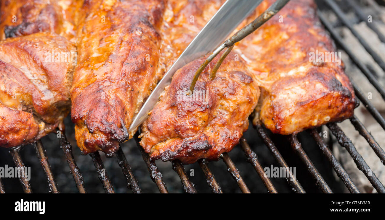 Cutting Up Meat on the Barbecue close up Stock Photo - Alamy