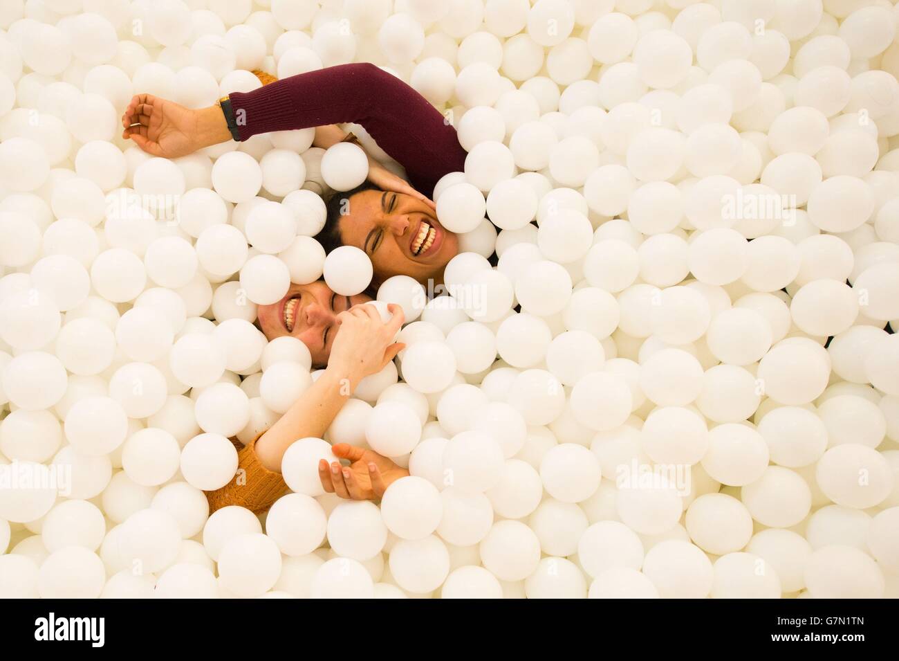 Visitors enjoy 'Jump In!', an adults-only ball pond holding over 80,000 ...