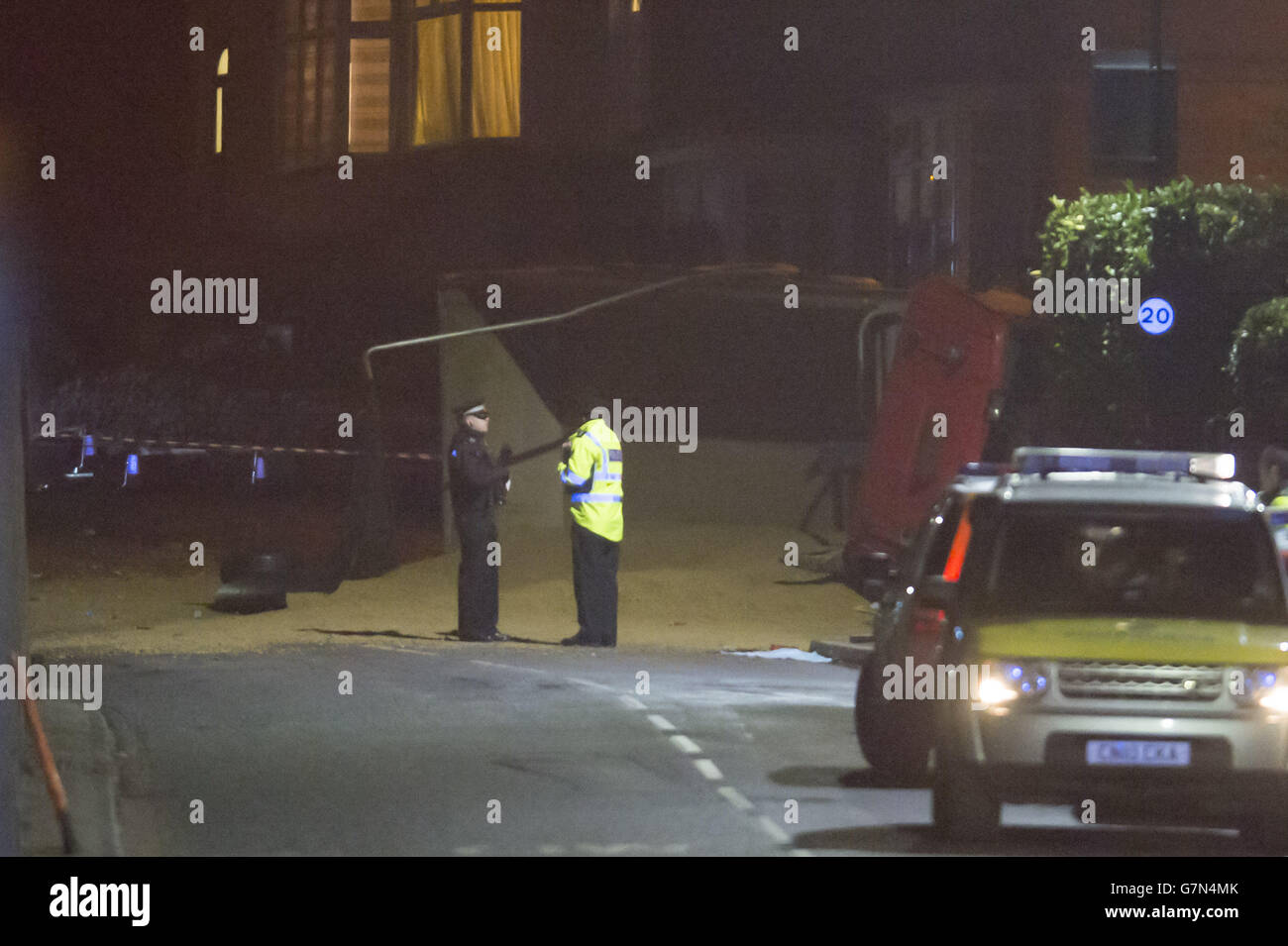 Police stand in front of a tipped over lorry after the tipper truck ...