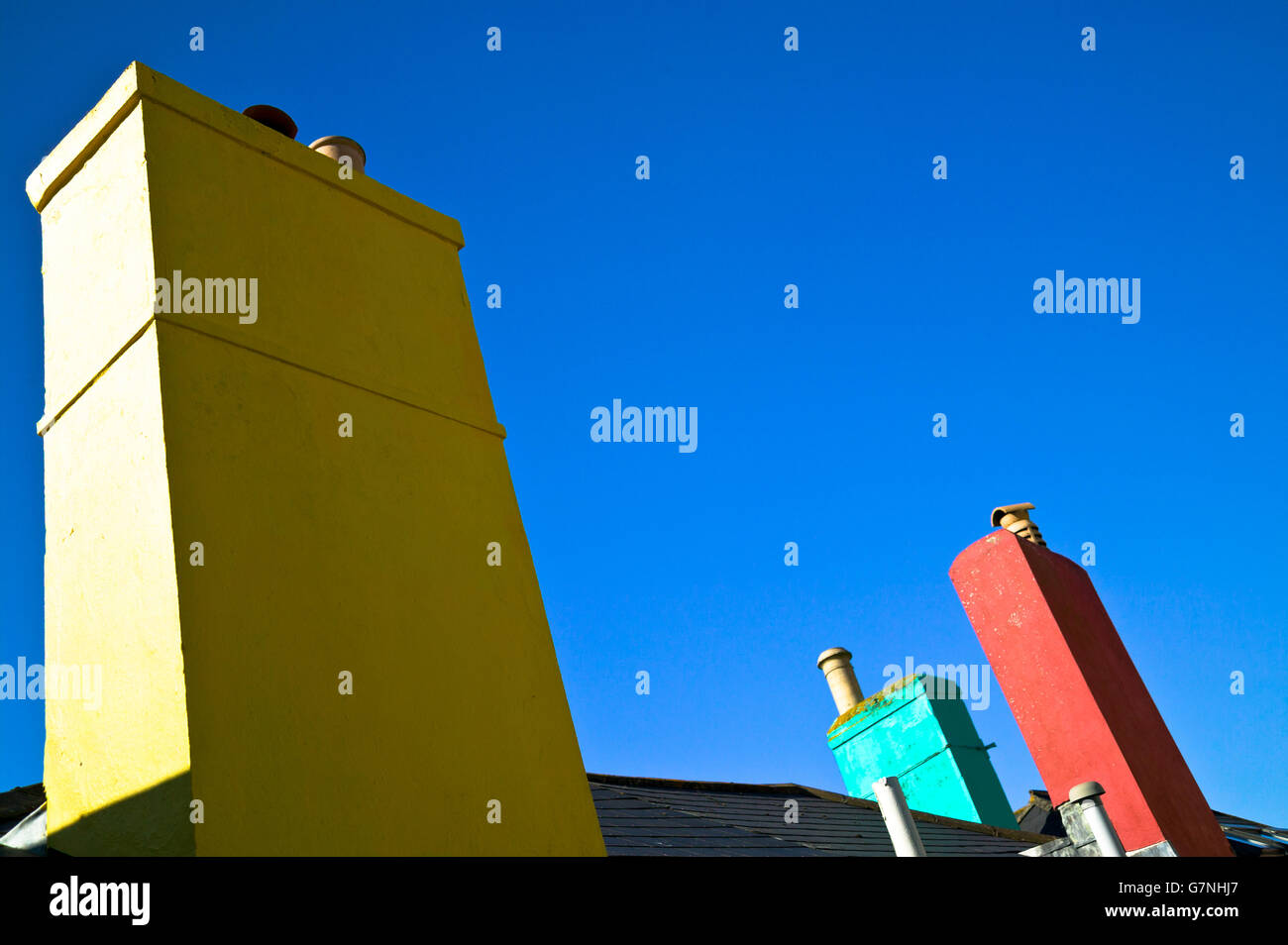 Colorful chimney tops in a deep blue summer sky Stock Photo - Alamy