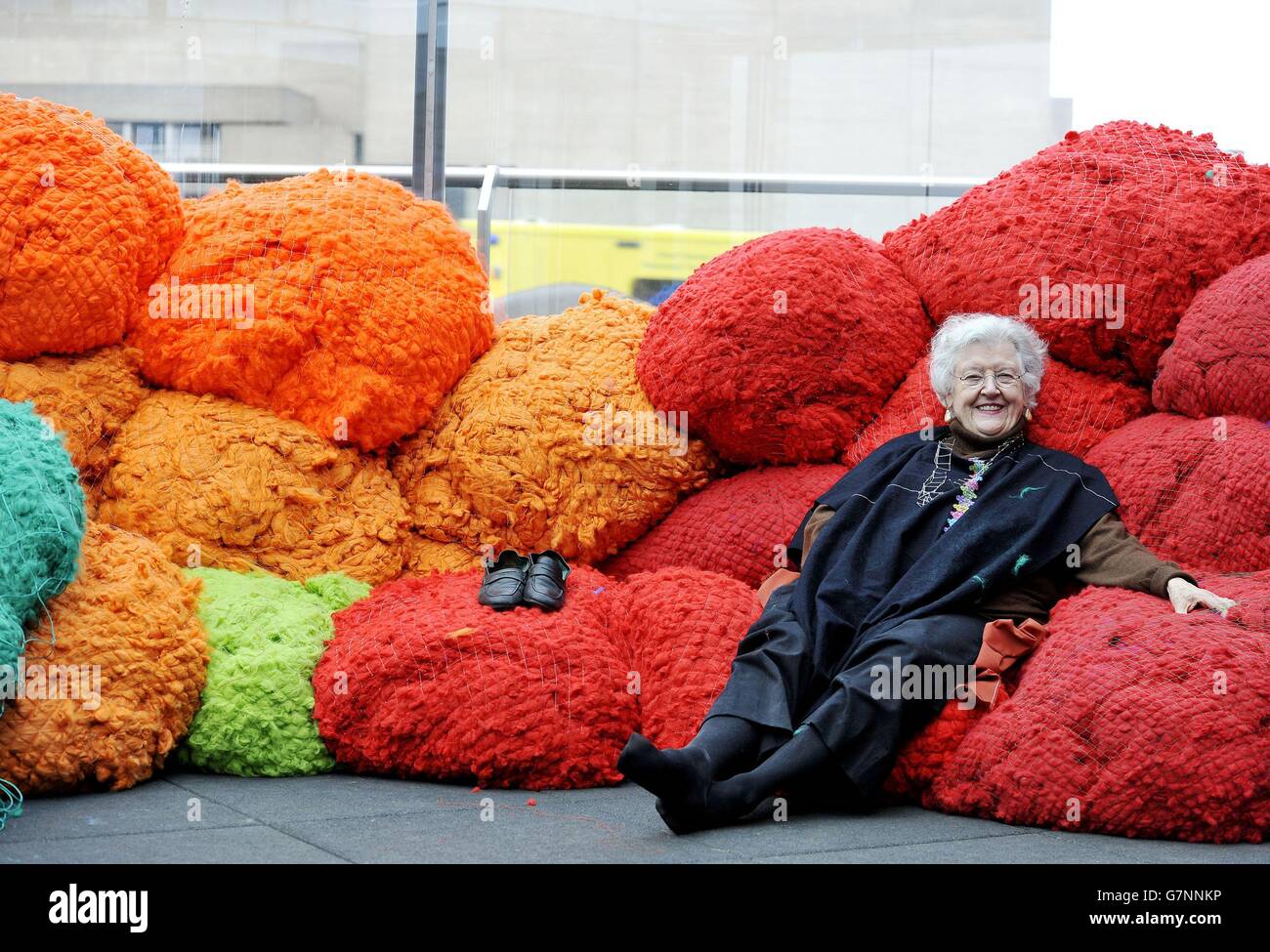Artist Sheila Hicks, sits on her installation made from large-scale ...