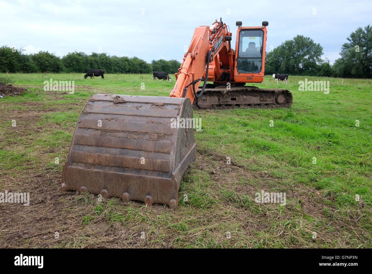 Orange 360 machine or digger being used for agricultural ditch or rhyne ...