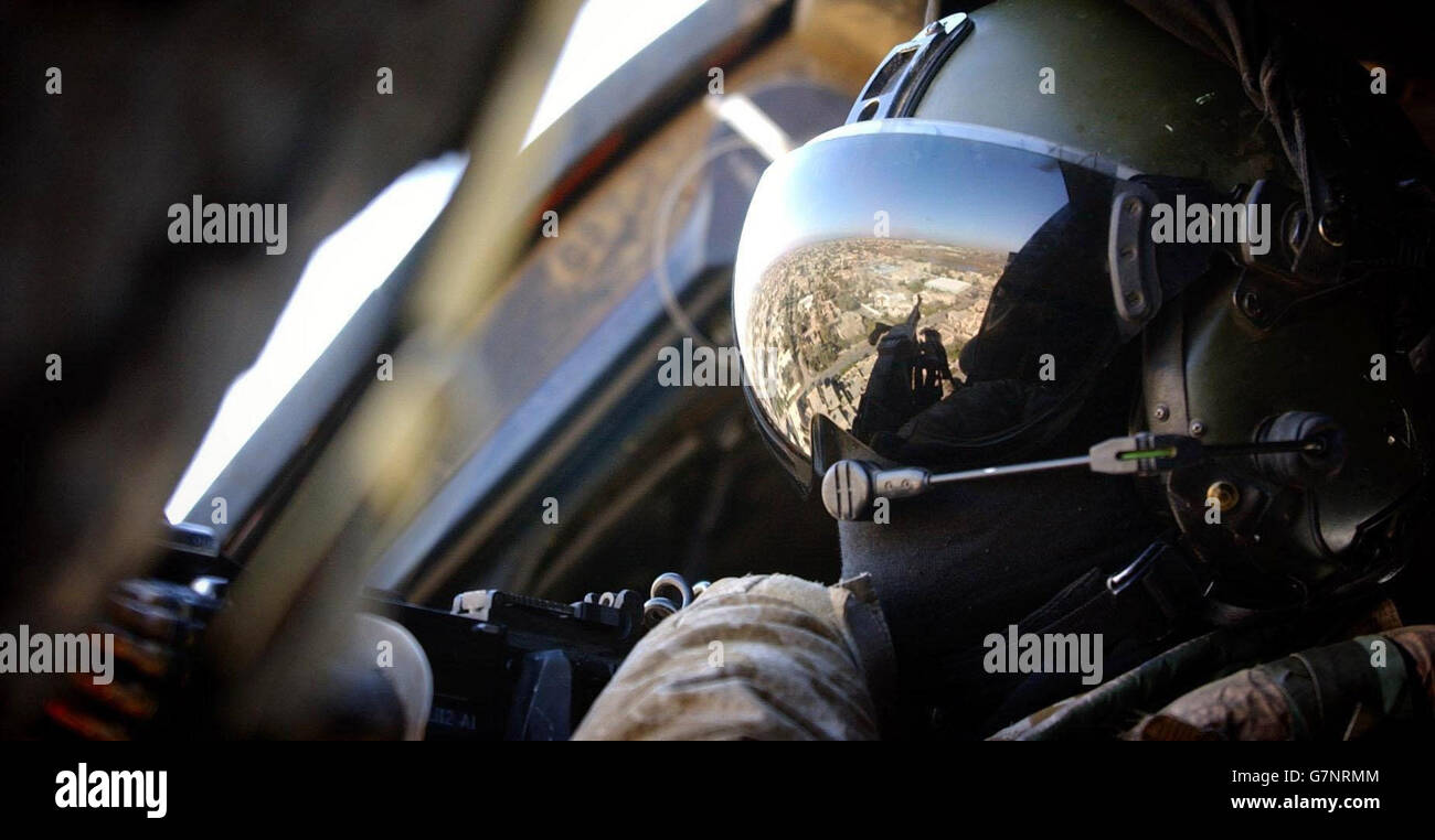 A crewman on board a Royal Air Force Puma helicopter mans a machine gun ...