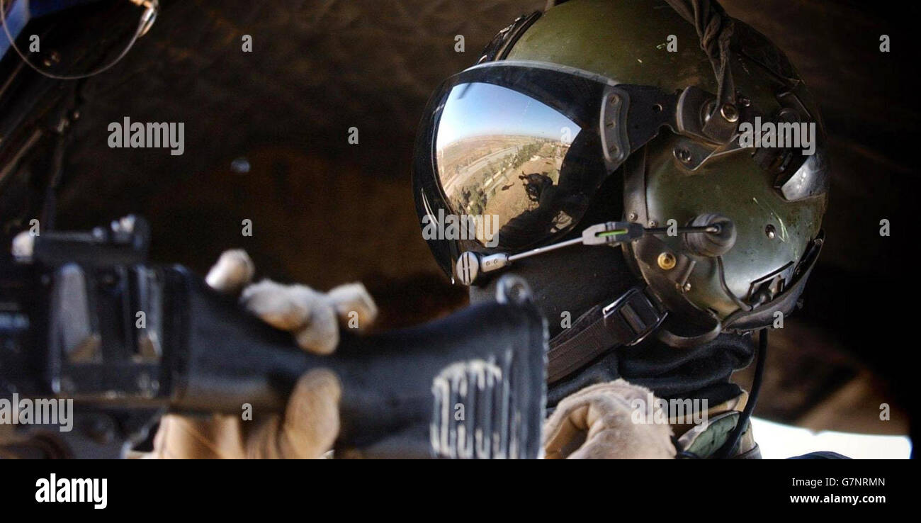 A crewman on board a Royal Air Force Puma helicopter mans a machine gun ...
