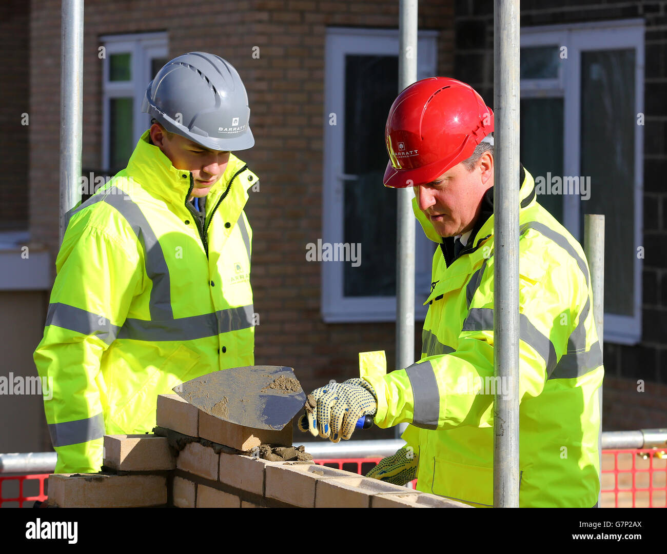 Prime Minister David Cameron (right) lays bricks with apprentice brick ...