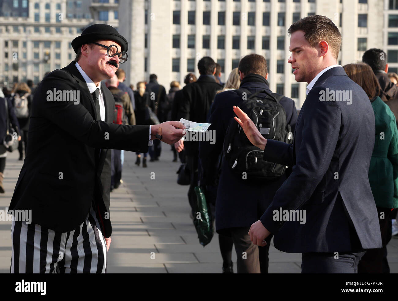 An actor, dressed as the tax man, hands out free £5 notes on London ...