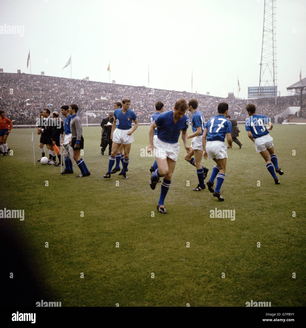 The Italy players warm up as the two teams line up before the match ...