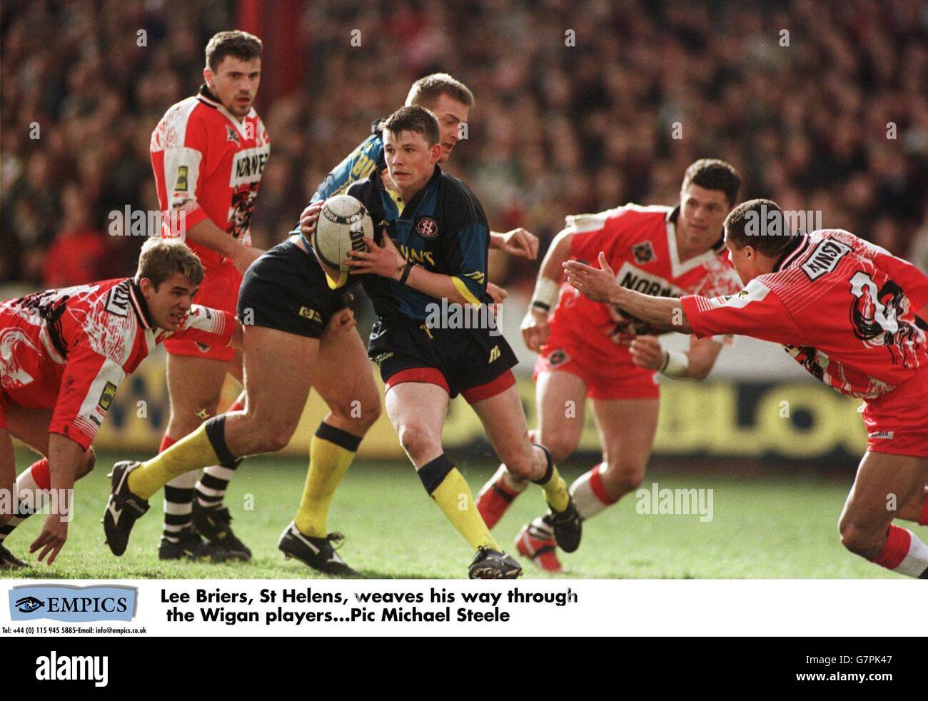 Lee Briers, St Helens, weaves his way through the Wigan players Stock ...