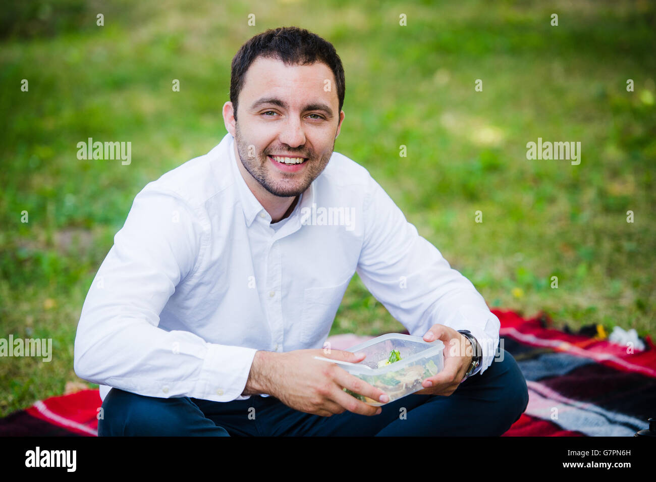 young business man enjoying food which he brought in a lunch box from ...