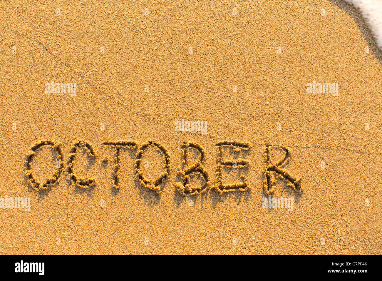 October - written on sandy beach Stock Photo - Alamy