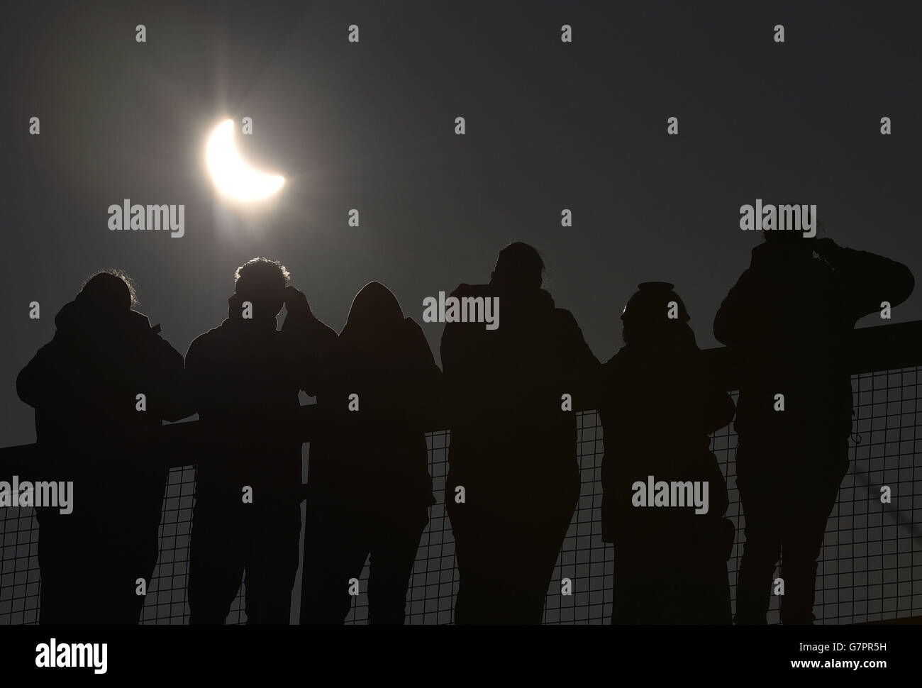 EDS NOTE: SOLAR FILTER HAS BEEN USED People watch as an eclipse of the ...