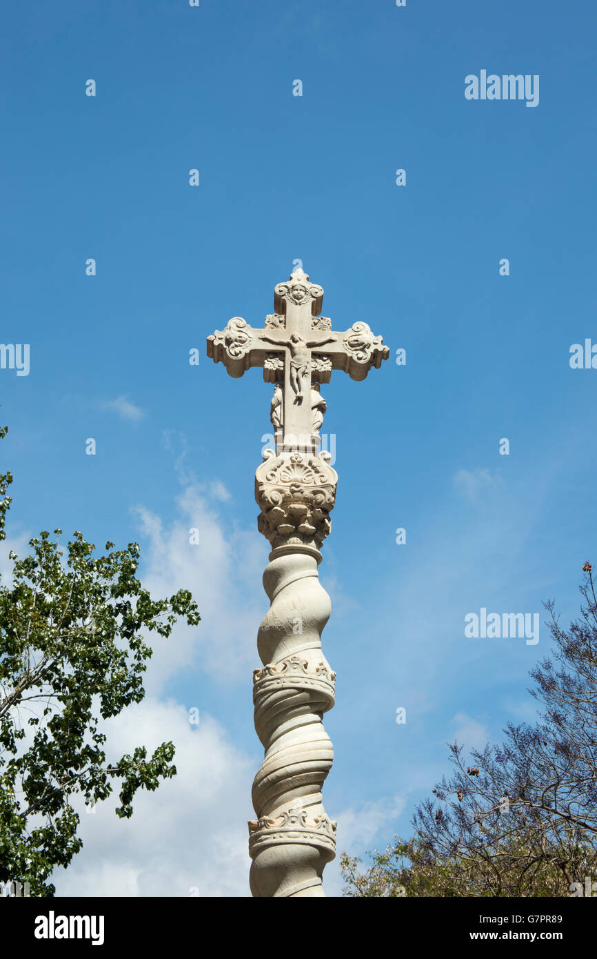 Detail of a holy cross carved in stone with blue sky at the background ...