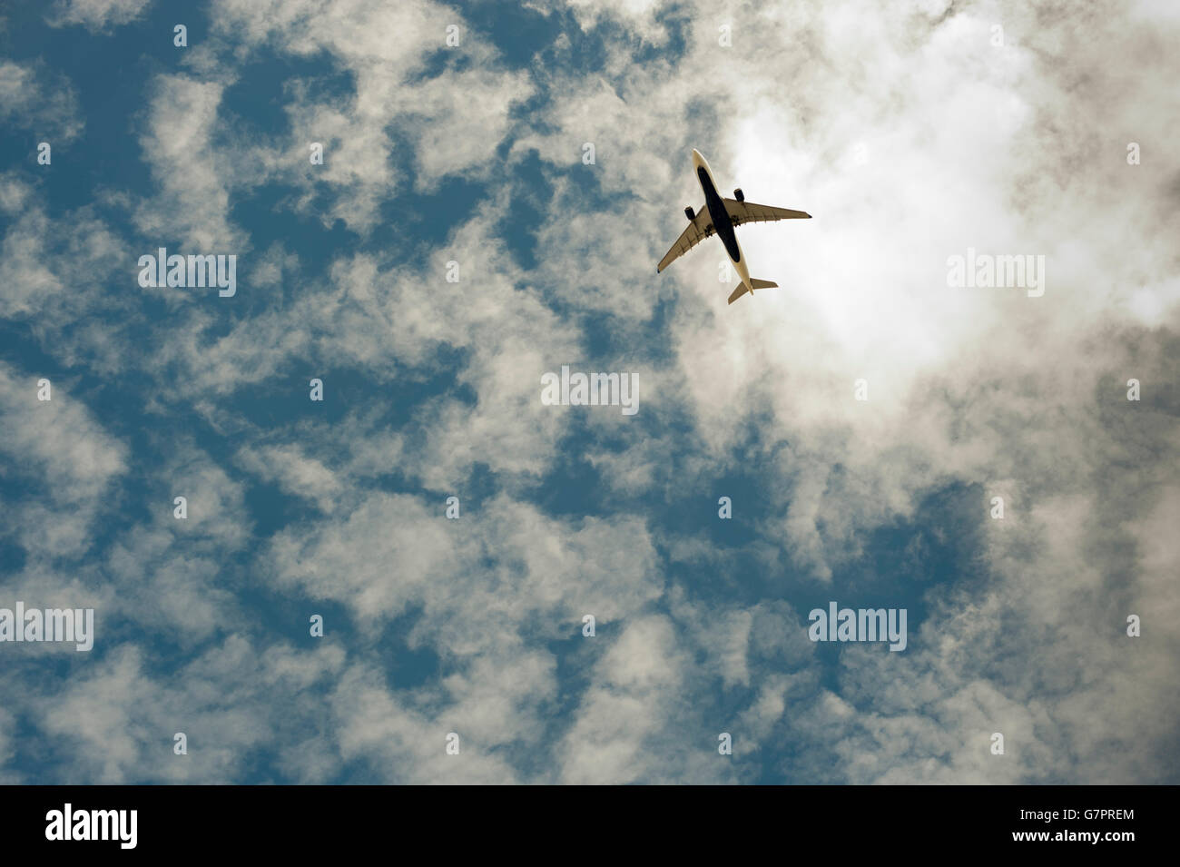 Commercial jet flying overhead in clouds Stock Photo - Alamy
