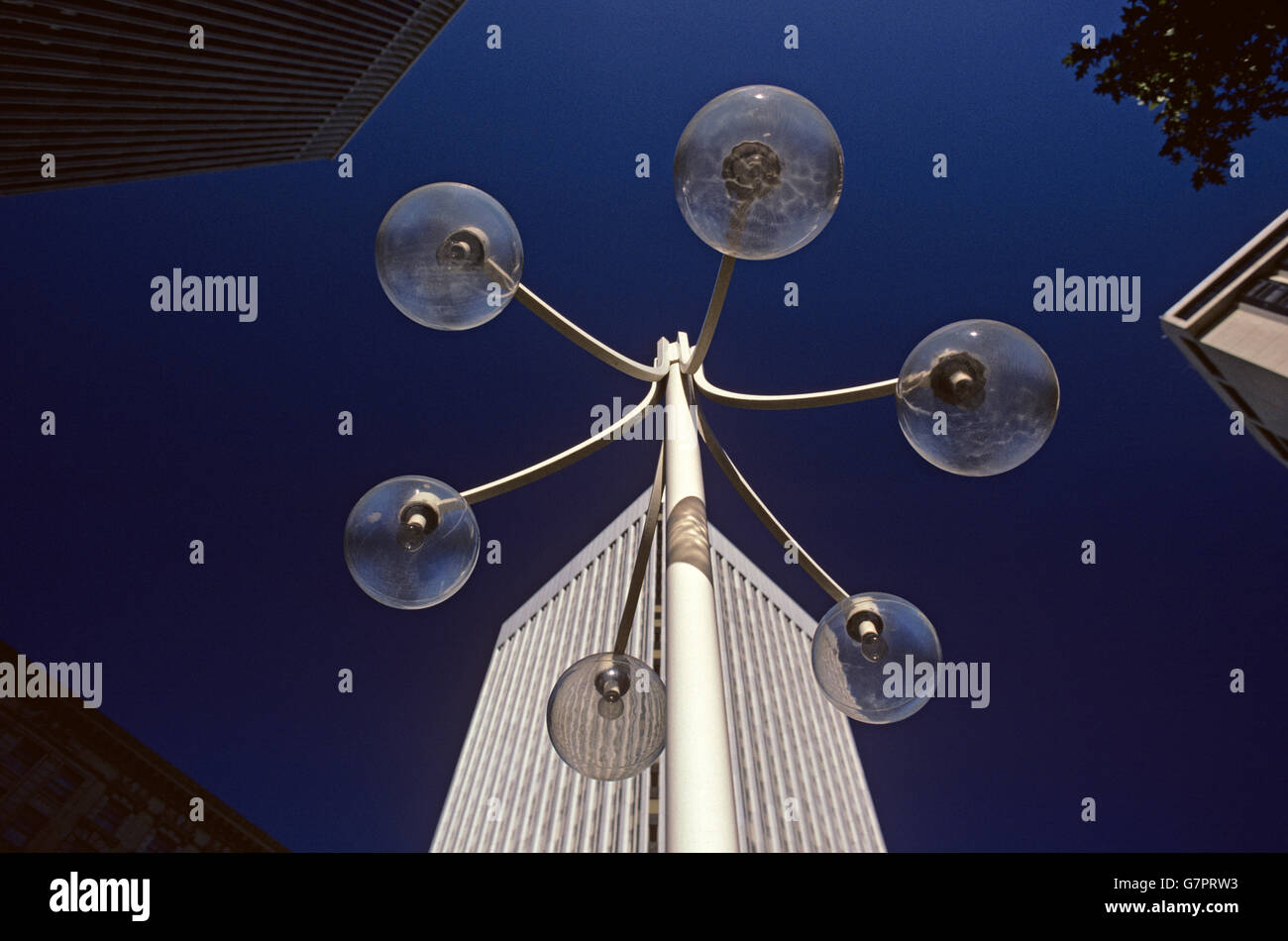 Looking up at lamp post with multiple bulbs and building with repeating ...