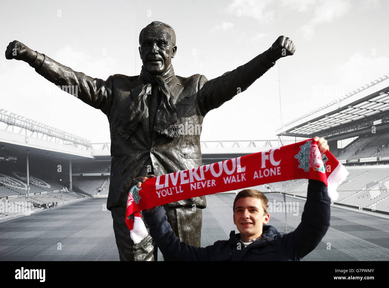 A fan poses for a photograph with his scarf outside Anfield before the ...