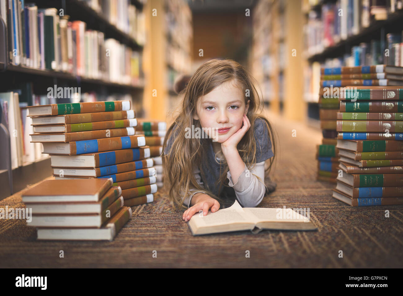 Stylish young girl reading in the library Stock Photo - Alamy