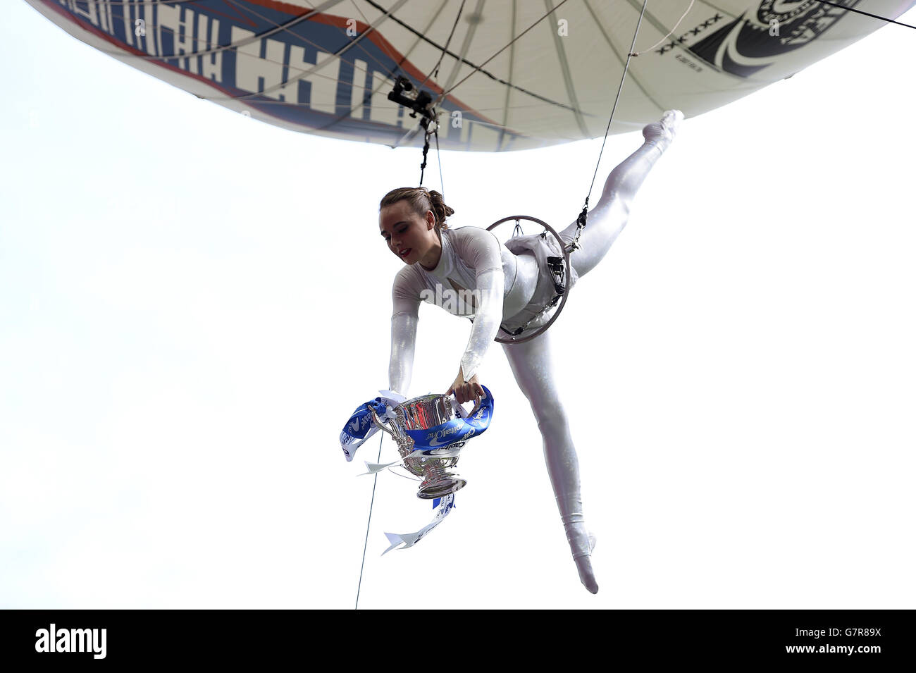 A high wire trapeze artist delivers the Capital One Cup before kick off ...