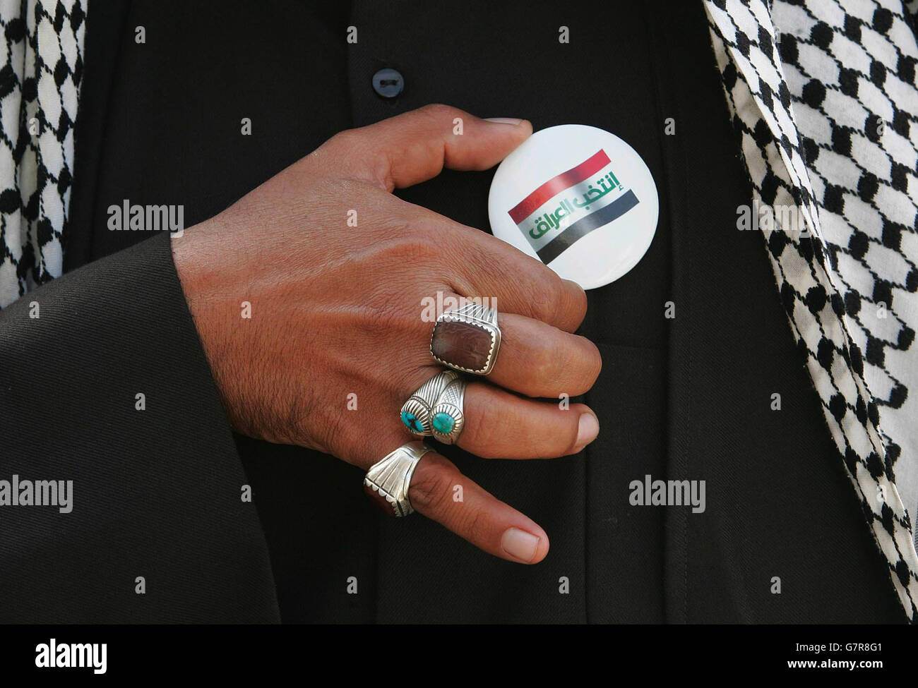 An Iraqi wears a badge of the Iraqi flag with an 'Elect Iraq' slogan on ...