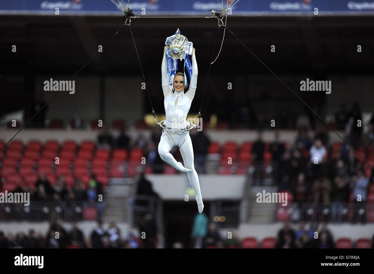 A high wire trapeze artist delivers the Capital One Cup before kick off ...