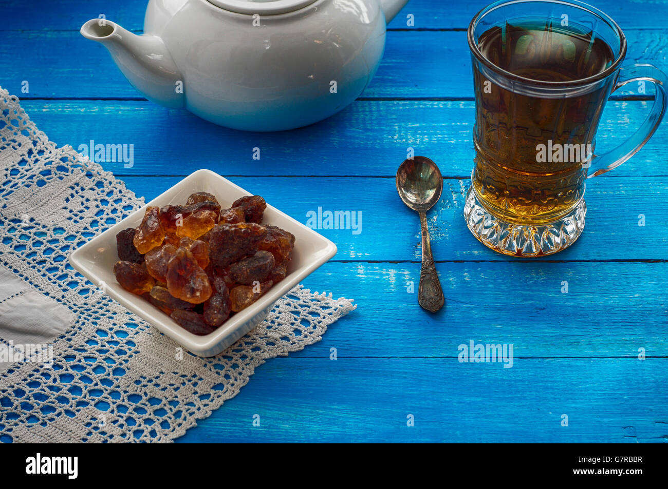 Tea in glass mug and a spoon on a vintage blue wooden table Stock Photo ...