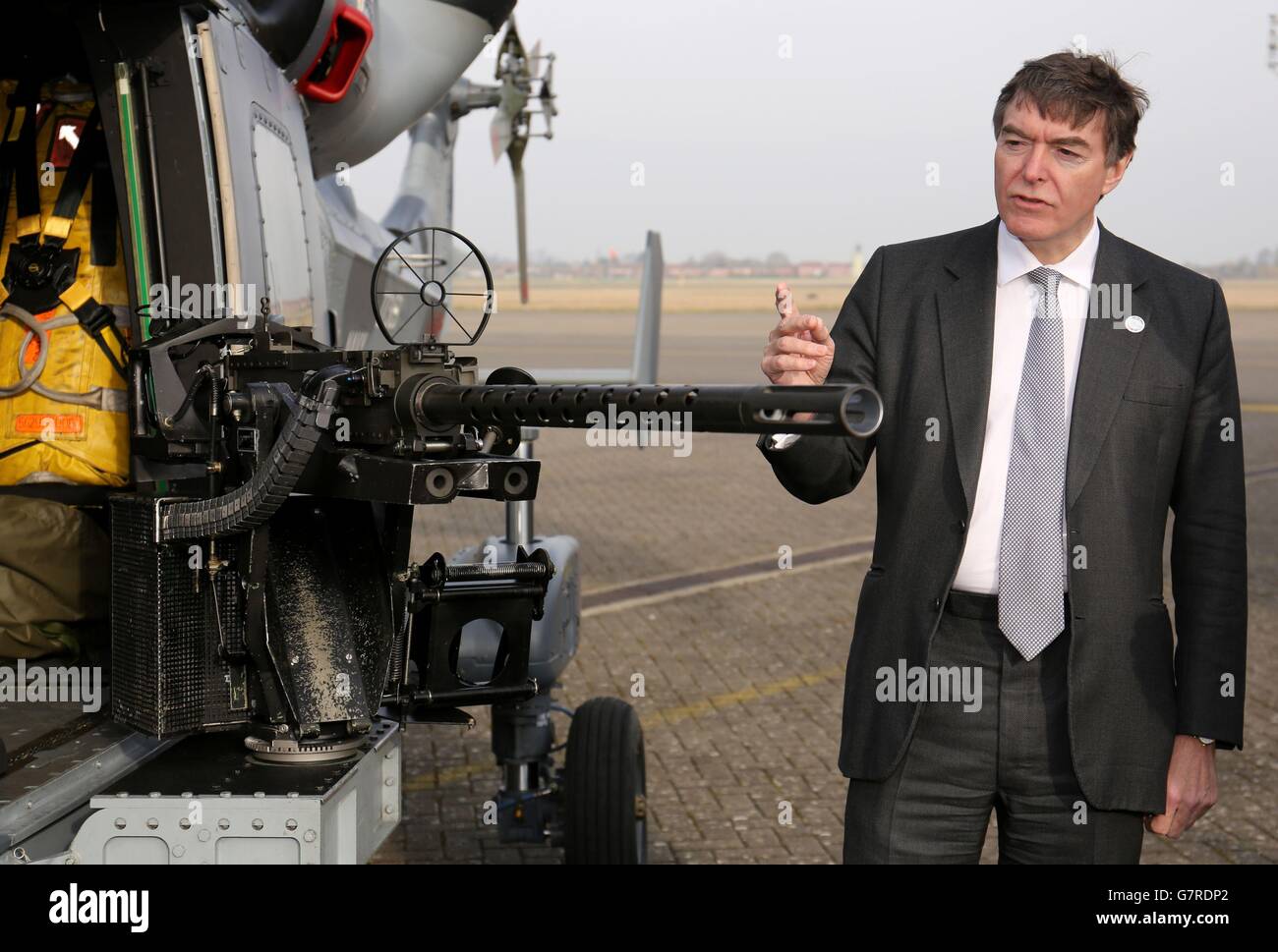 Defence Minister Philip Dunne stands next to a Wildcat helicopter ...