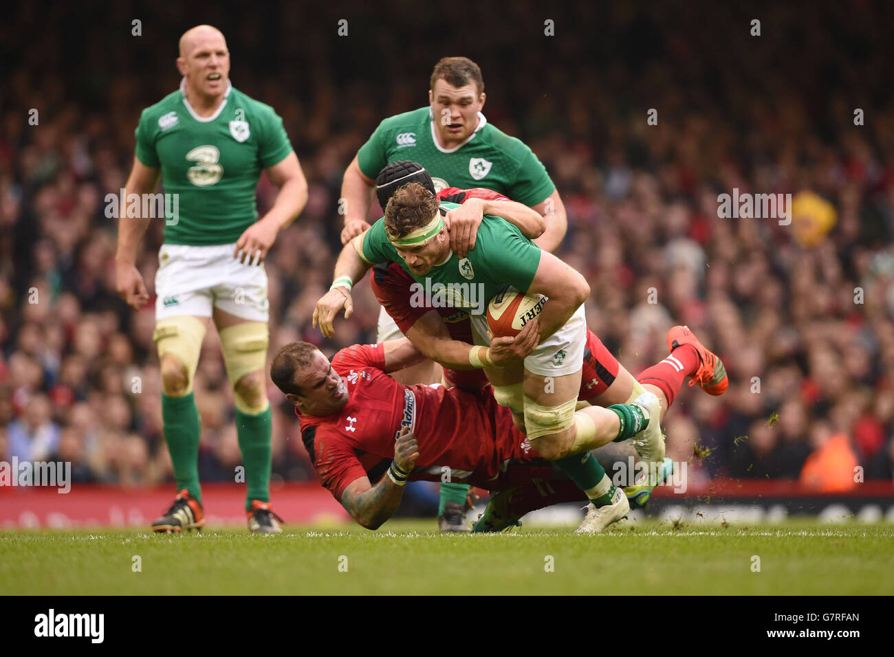 Ireland's Jamie Heaslip is tackled by Wales' Jamie Roberts and Luke ...