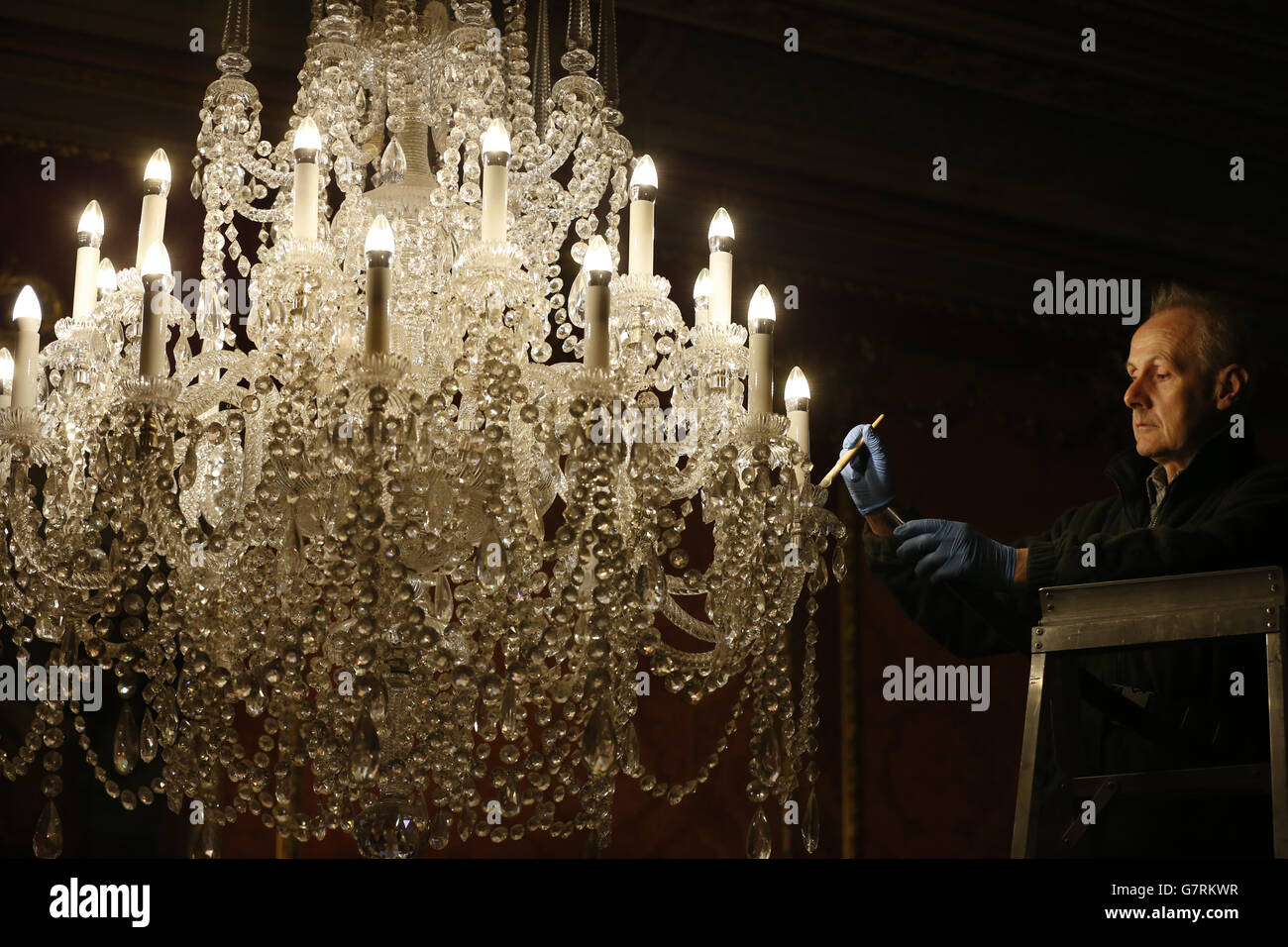 Conservator Robin Matthews removes the dust from a chandelier at ...