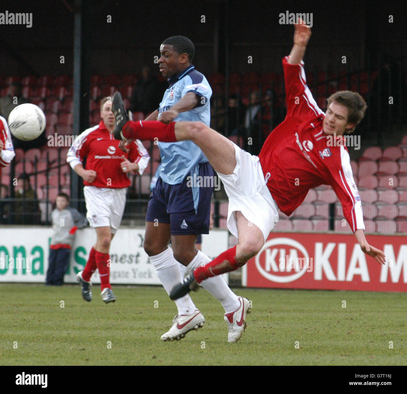 Woking striker Justin Richards is challenged by York's Jonathan Maloney ...