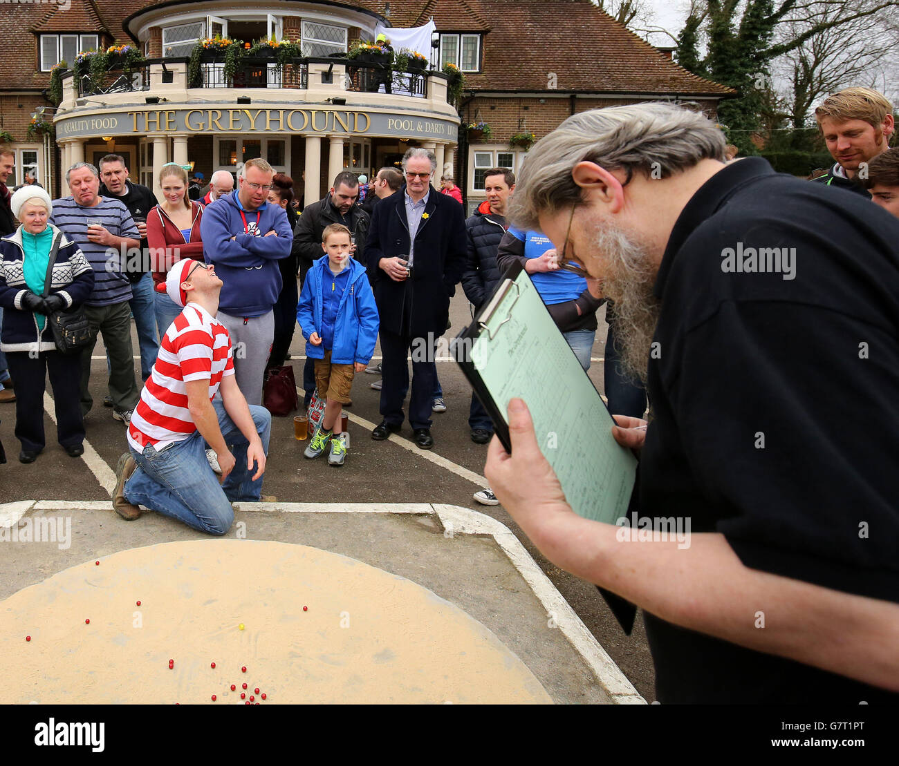 A member of the Where's Tolley marbles team reacts after taking a shot ...