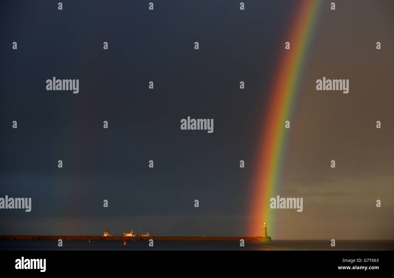A rainbow appears over the lighthouse at Tynemouth this evening as the ...