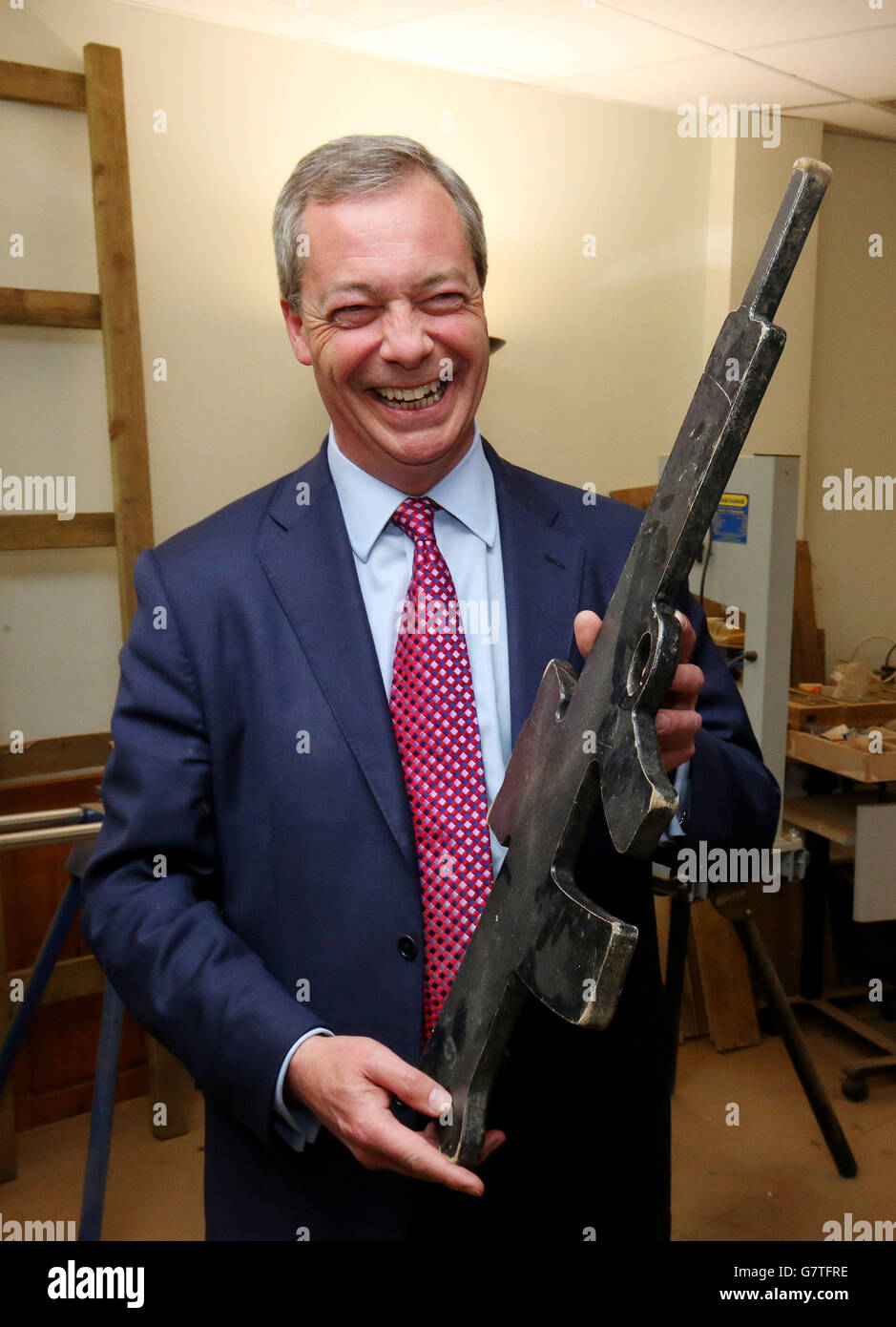 Ukip leader Nigel Farage looks at items being made in the wood craft ...