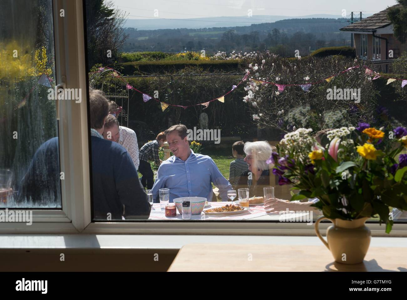 Prime Minister David Cameron (centre) eats lunch in a garden with the ...