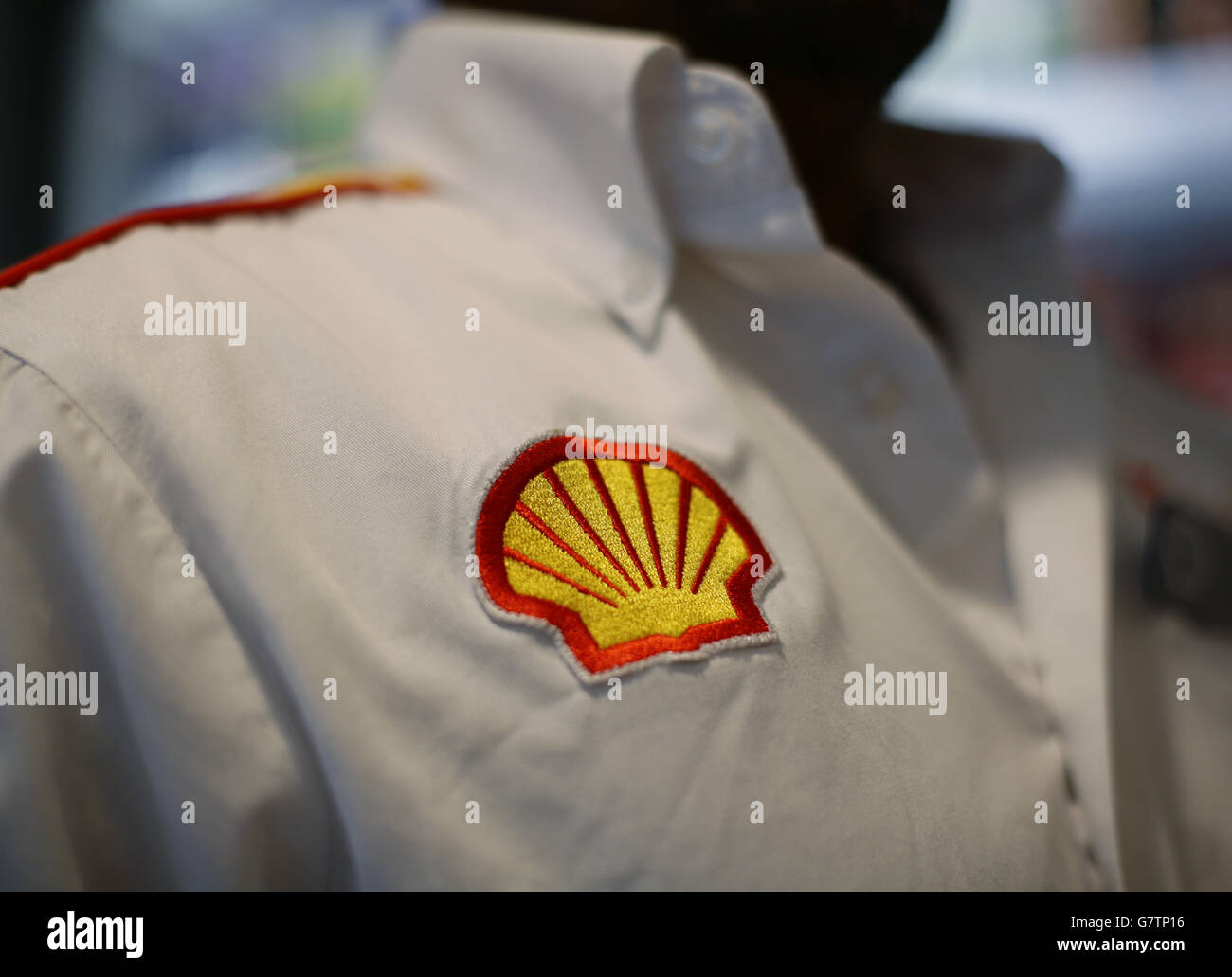A Shell logo on the shirt of a member of staff at a Shell petrol ...