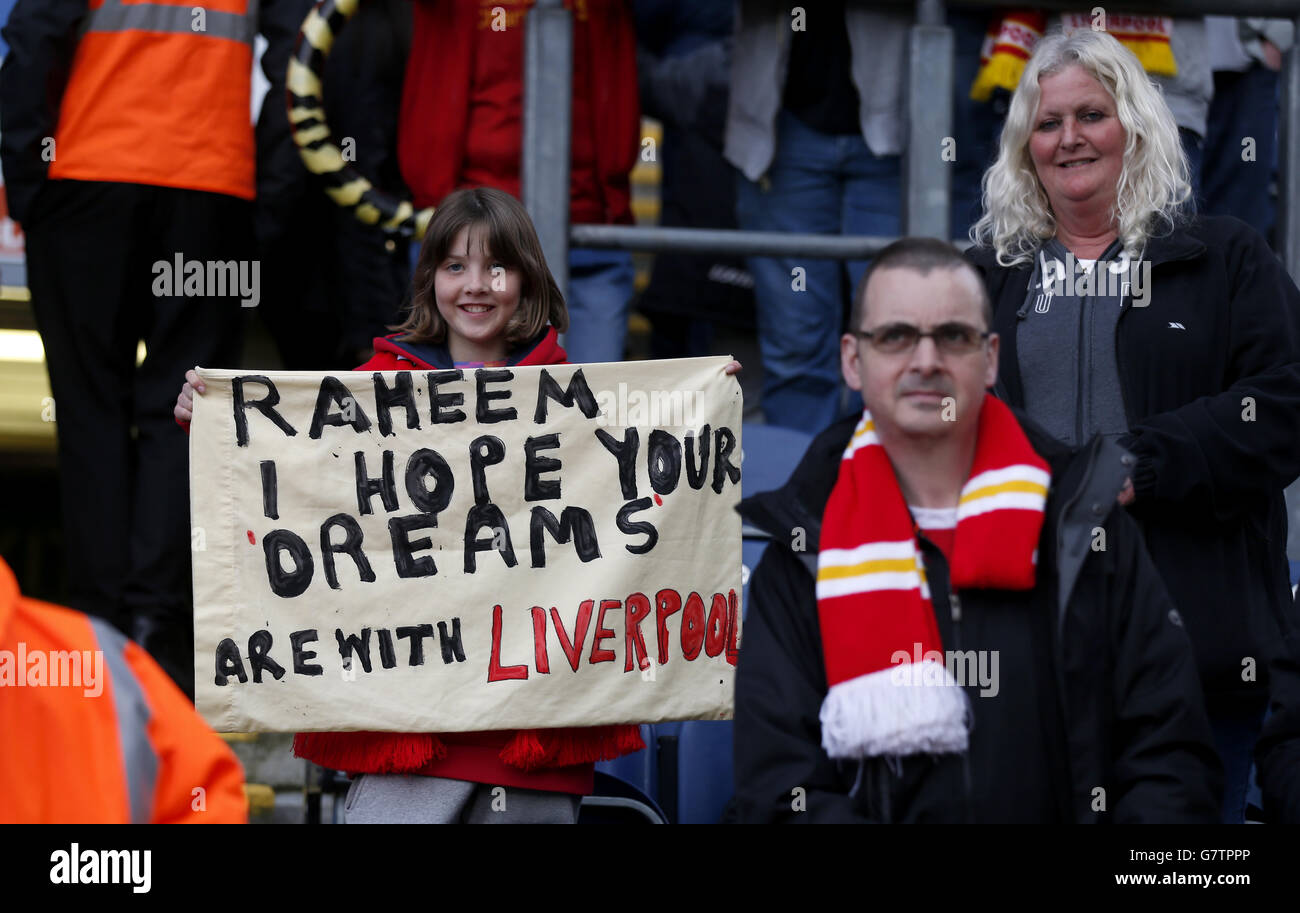A young Liverpool fan holds up a banner that reads 'Raheem I Hope Your ...