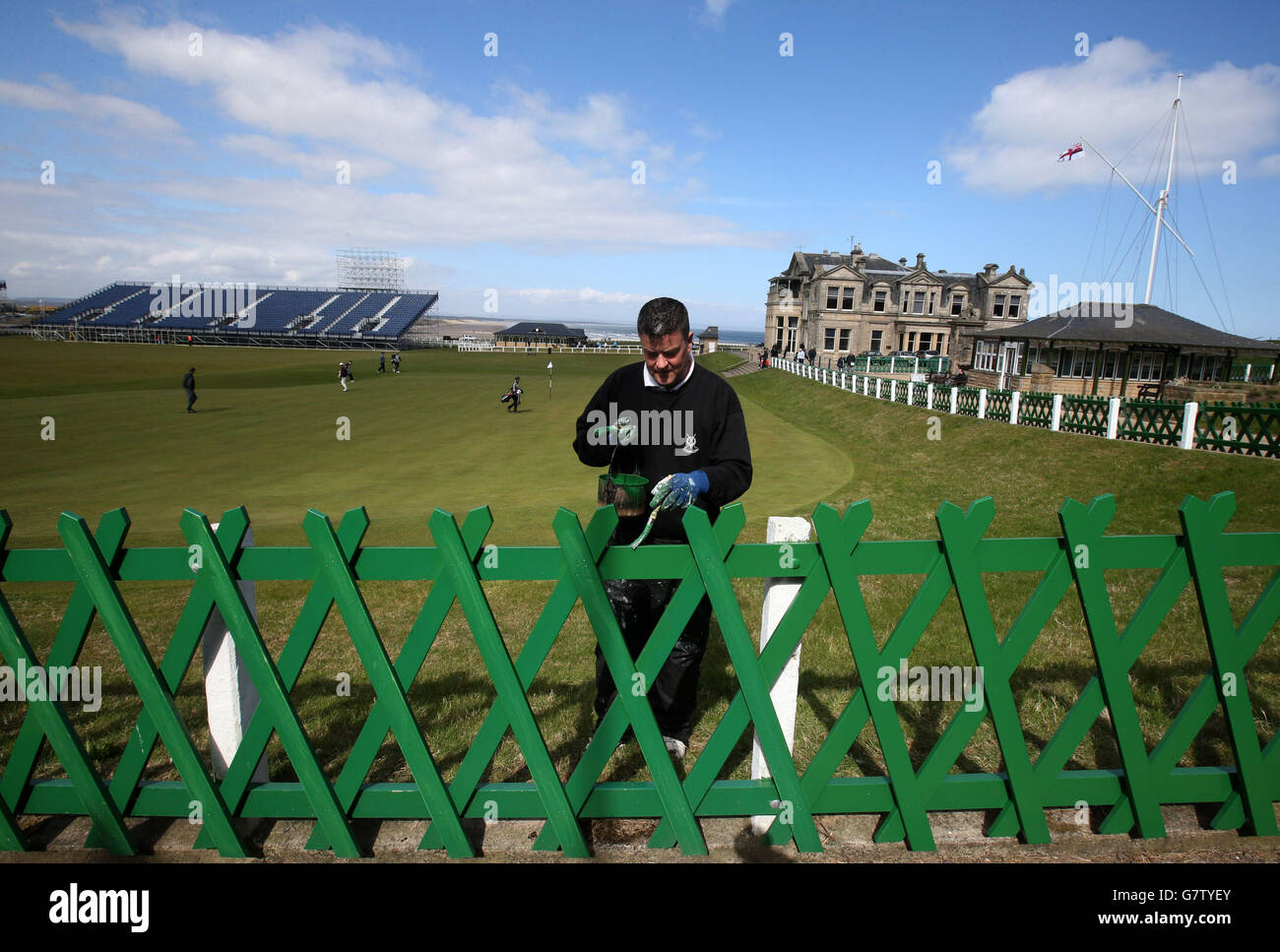 A fence is painted around the 18th green as stands are put up ahead of ...
