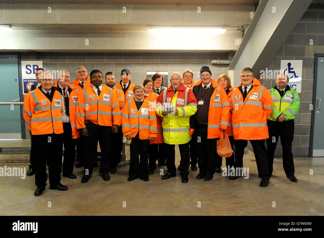 Wigan Athletic match day stewards pose for a photo as they hold a ...