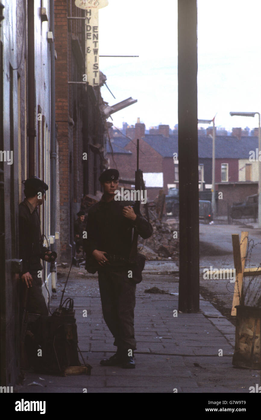 Troops on guard beside barriers in the Falls Road area of Belfast Stock ...