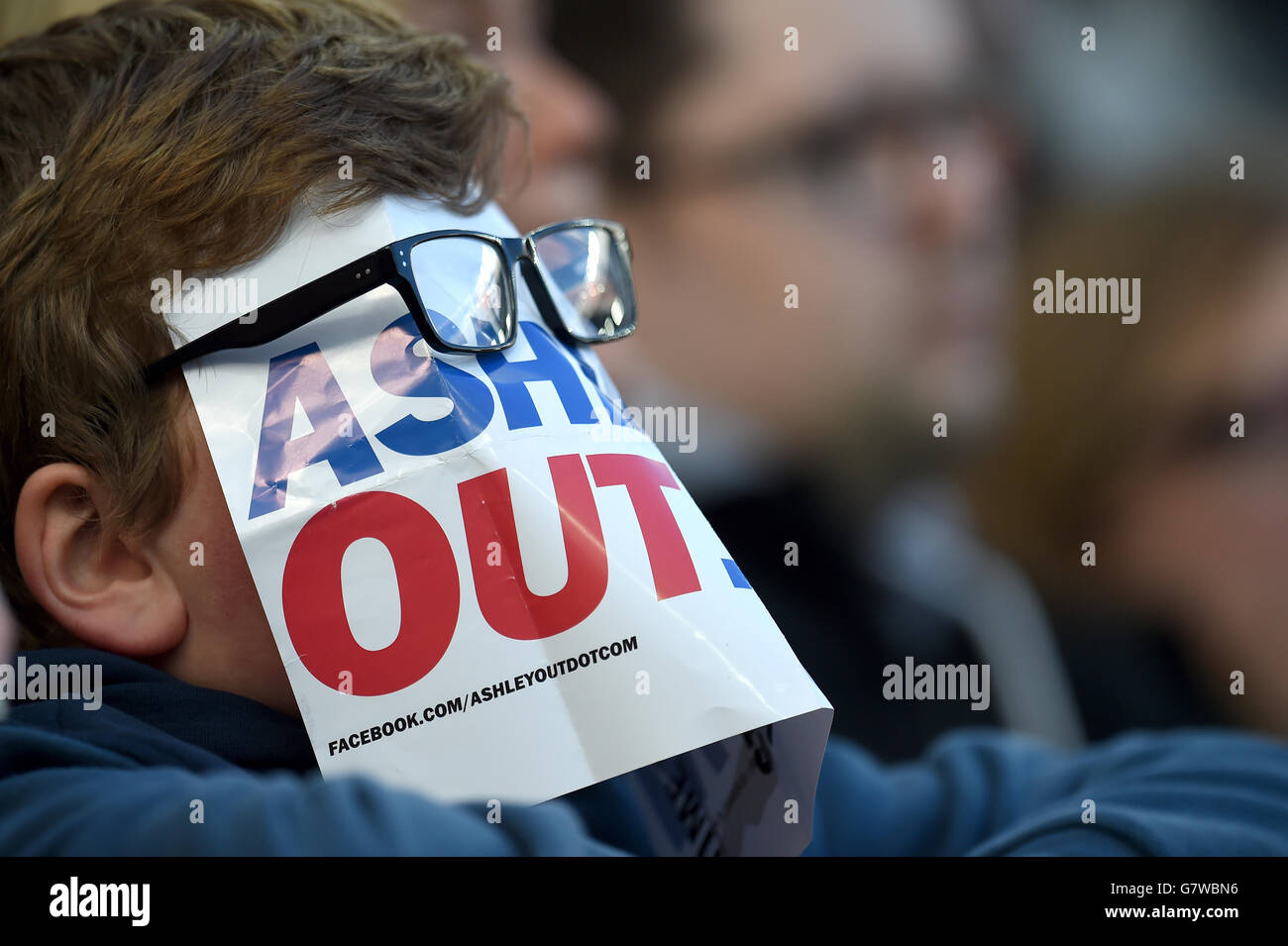 A Newcastle United fan covers his face with a protest sign in the ...