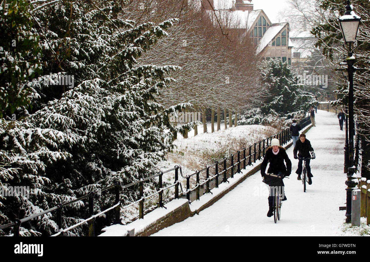 Students cycle through the snow in the college backs hi-res stock ...