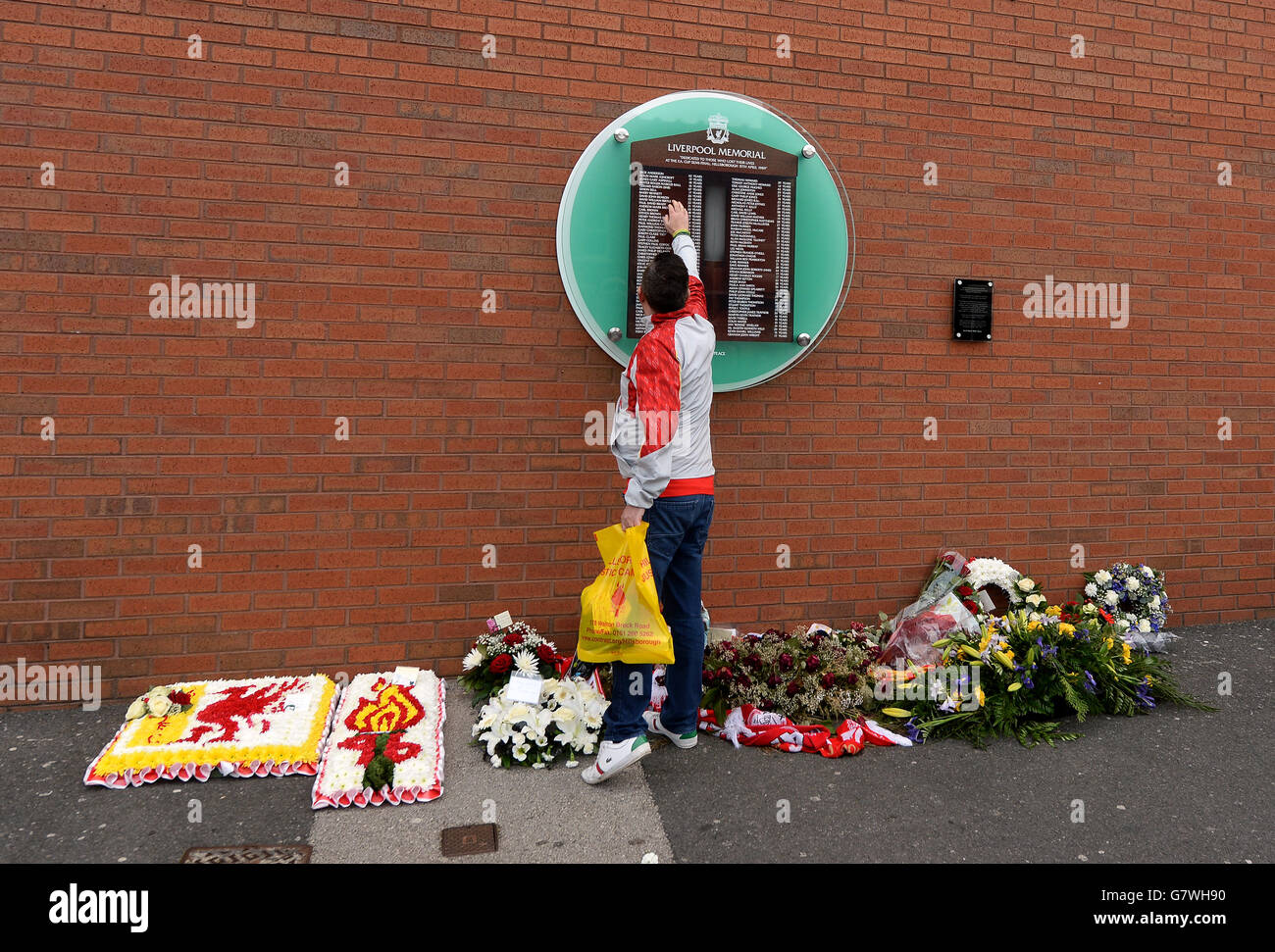 A Liverpool fan touches the Liverpool memorial for the Hillsborough ...